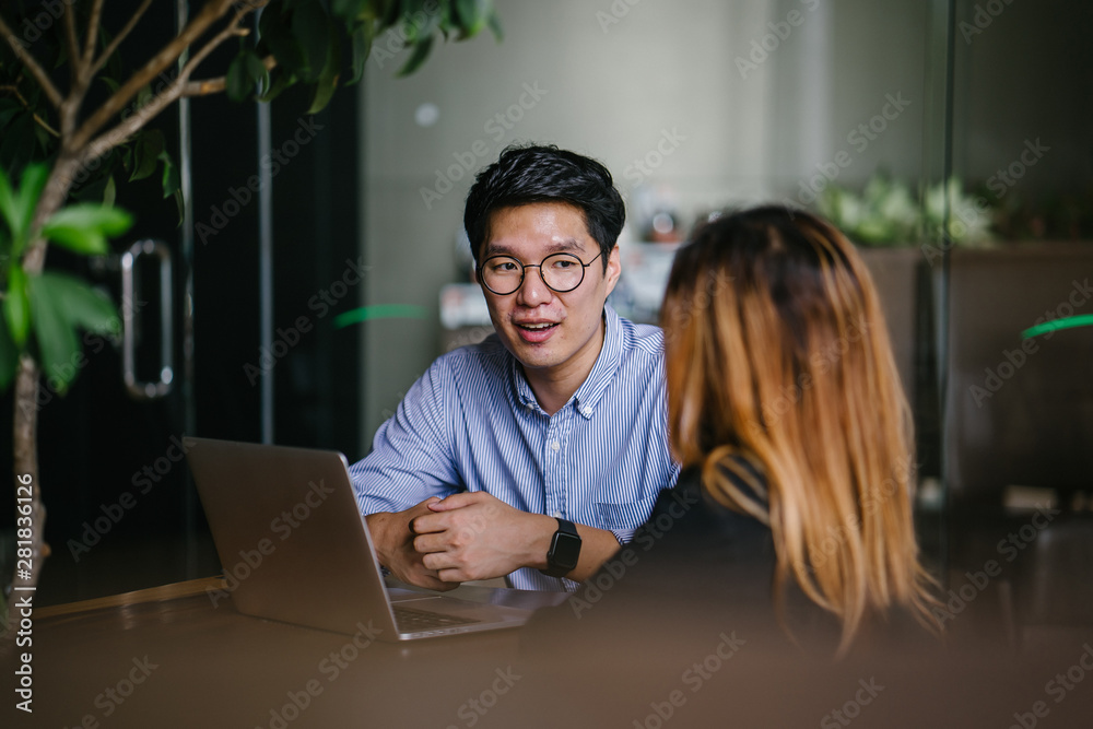 A pair of diverse team mates have a business meeting and discussion ...