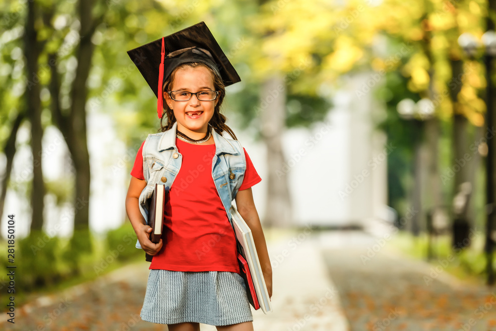 Authentic shot of cute little elegant girl with graduation hat is ...