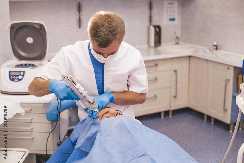 Doctor in a modern clinic preparing for a vampire facelift procedure of ...