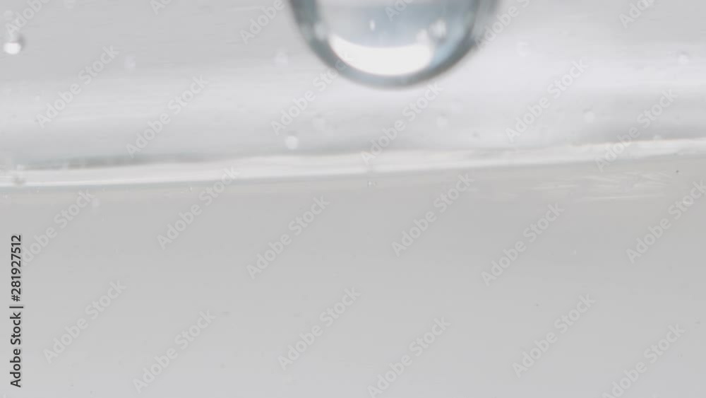 Slow motion macro footage of liquids connecting with a thin thread of ...