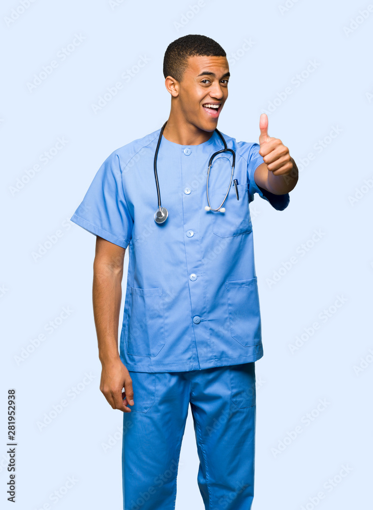 Surgeon doctor man giving a thumbs up gesture because something good ...