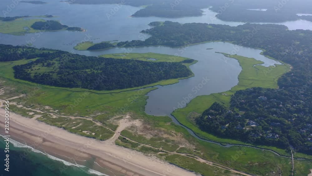 The cold waters of the Atlantic Ocean bathe a scenic beach on Cape Cod ...