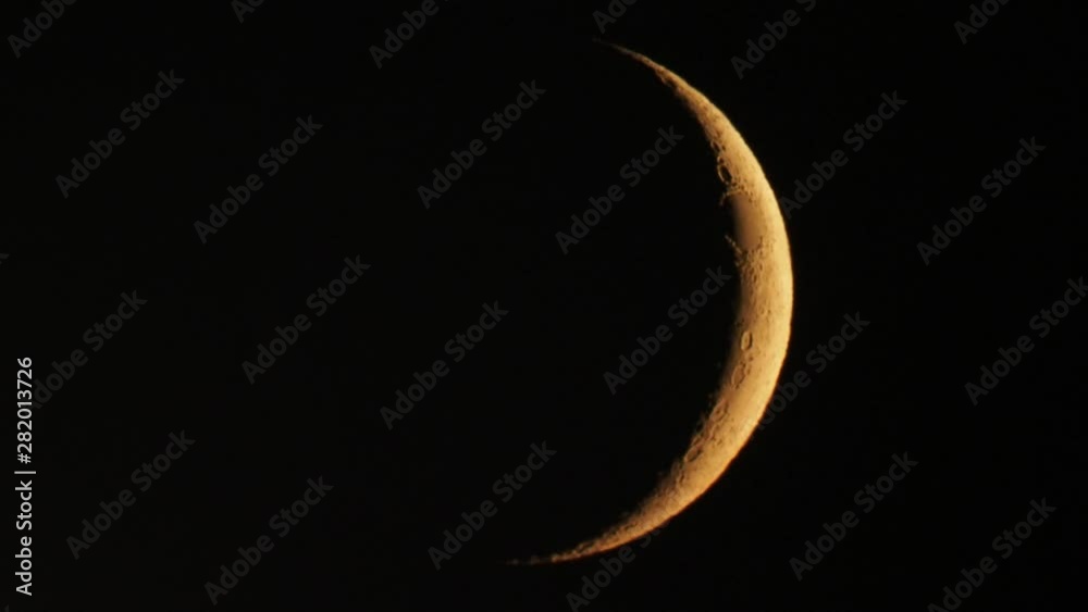 Waxing crescent moon seen with telescope in hot summer night, moon ...