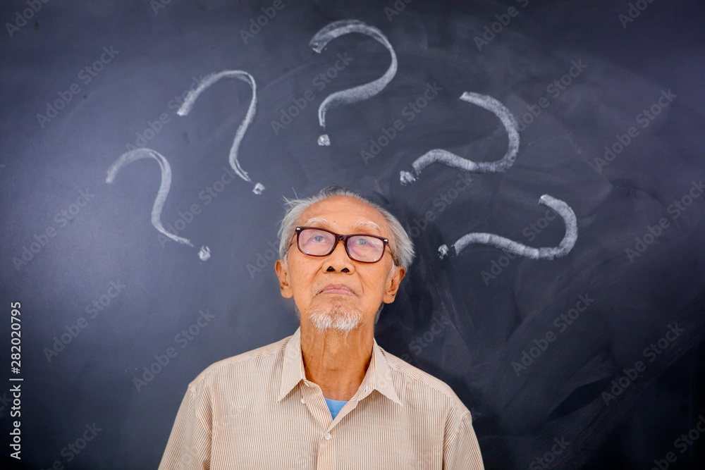 Elderly man looking at question marks Stock Photo | Adobe Stock