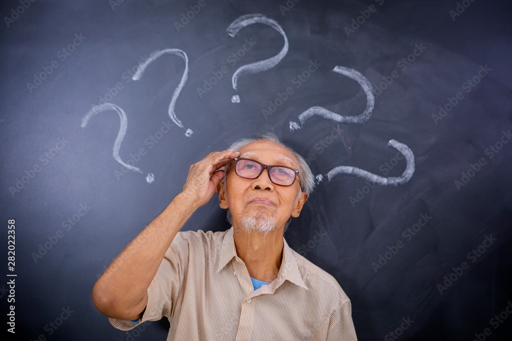 Foto Stock Old man thinking an idea under question marks | Adobe Stock