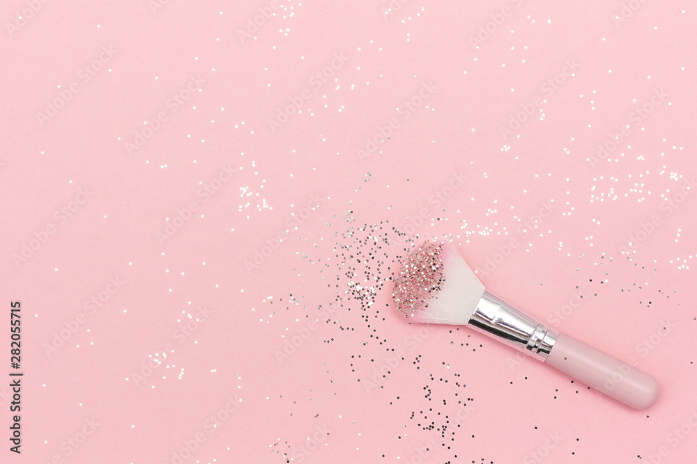 Makeup brush and shiny sparkles on pastel pink background. Festive ...