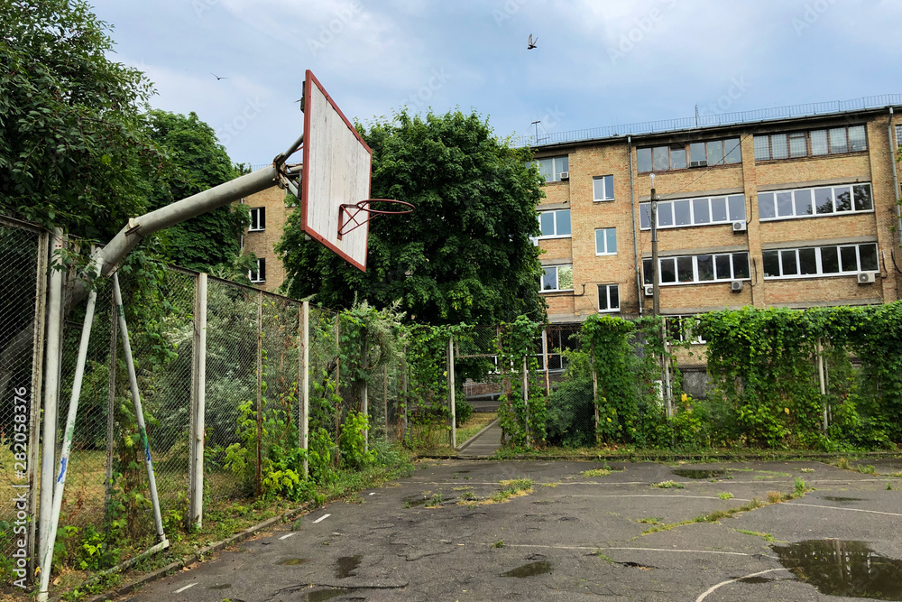 Old outdoor basketball court with puddles in the local residential area ...