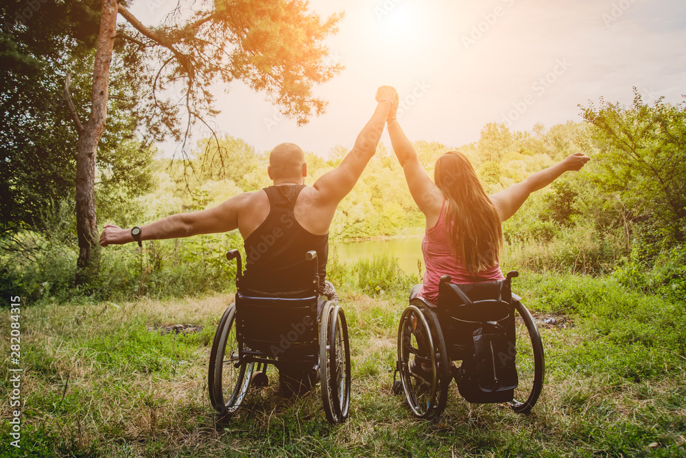 Handicapped couple resting in the forest near lake. Wheelchairs in the ...