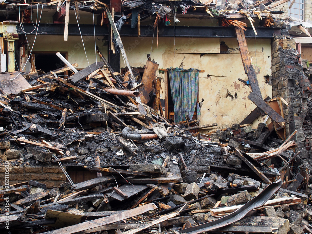 black burned timbers and walls in a collapsed house destroyed by fire ...