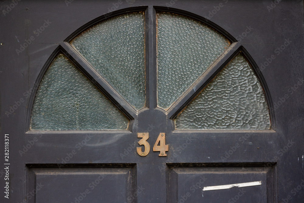 House number 34 on a brown front door Stock Photo | Adobe Stock