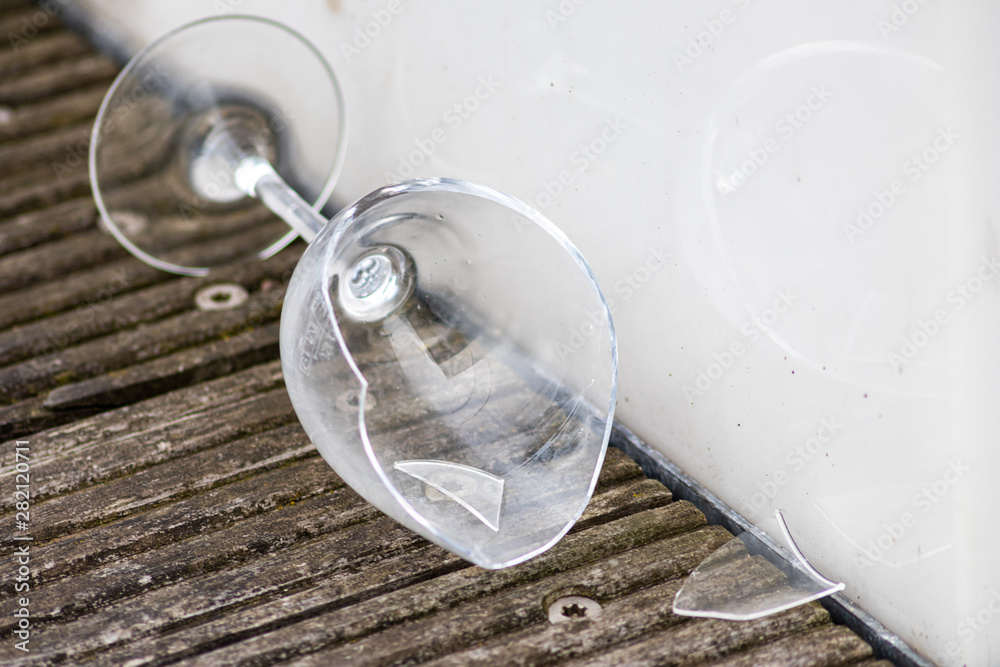 Stockfoto med beskrivningen Zerbrochenes Weinglas liegt auf Holzdielen ...