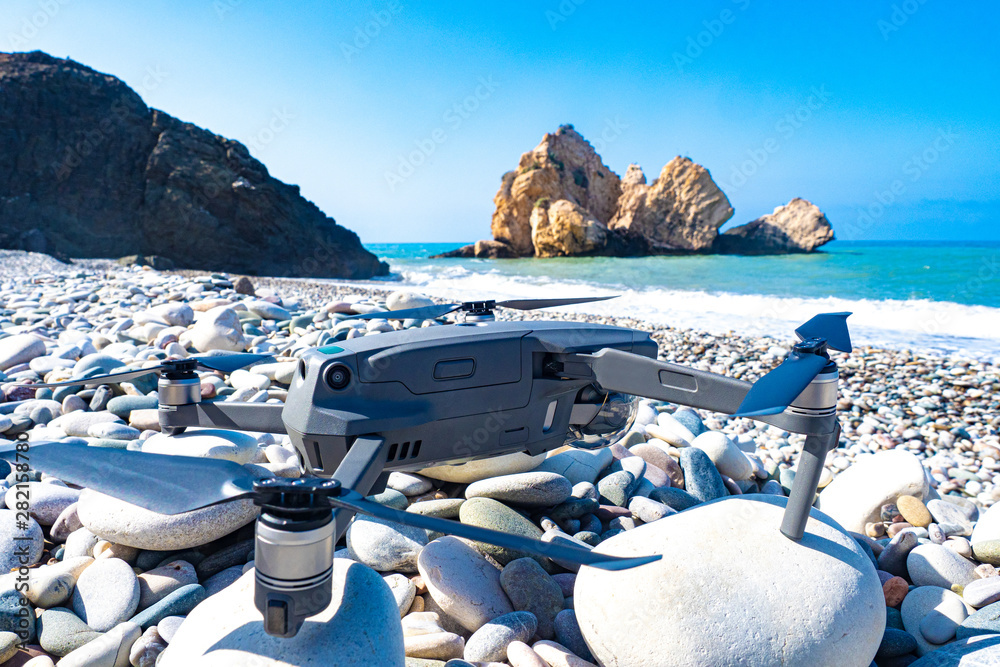 The quadcopter is on the beach. Quadrocopter against the sea, pebbles ...