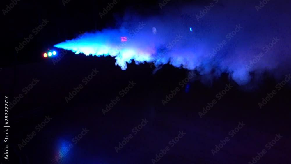 Disco Fog. A jet of stage smoke in the colorful beams of LED lights ...