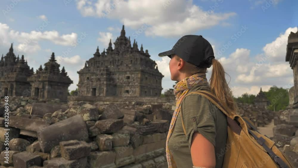 Tourist woman backpacker exploring the Prambanan temple in Java island ...