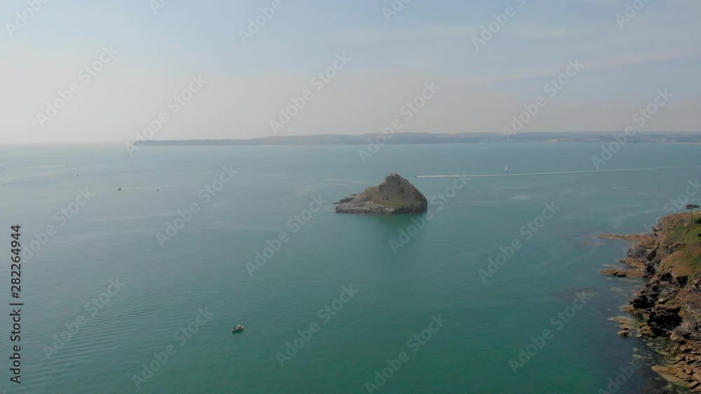 An aerial forward footage of a rocky island rock (Thatcher Point) with ...