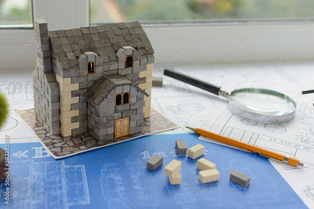 miniature house on the table with graphs, drawings, construction ...