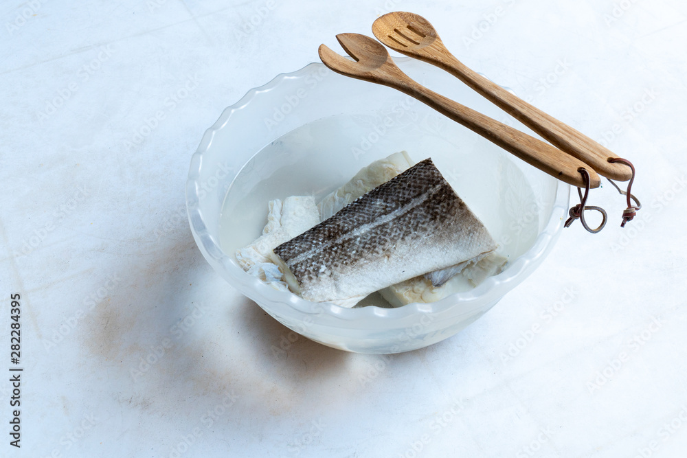 Salted and dried cod fish (Gadus morhua) in plastic bowl filled with ...