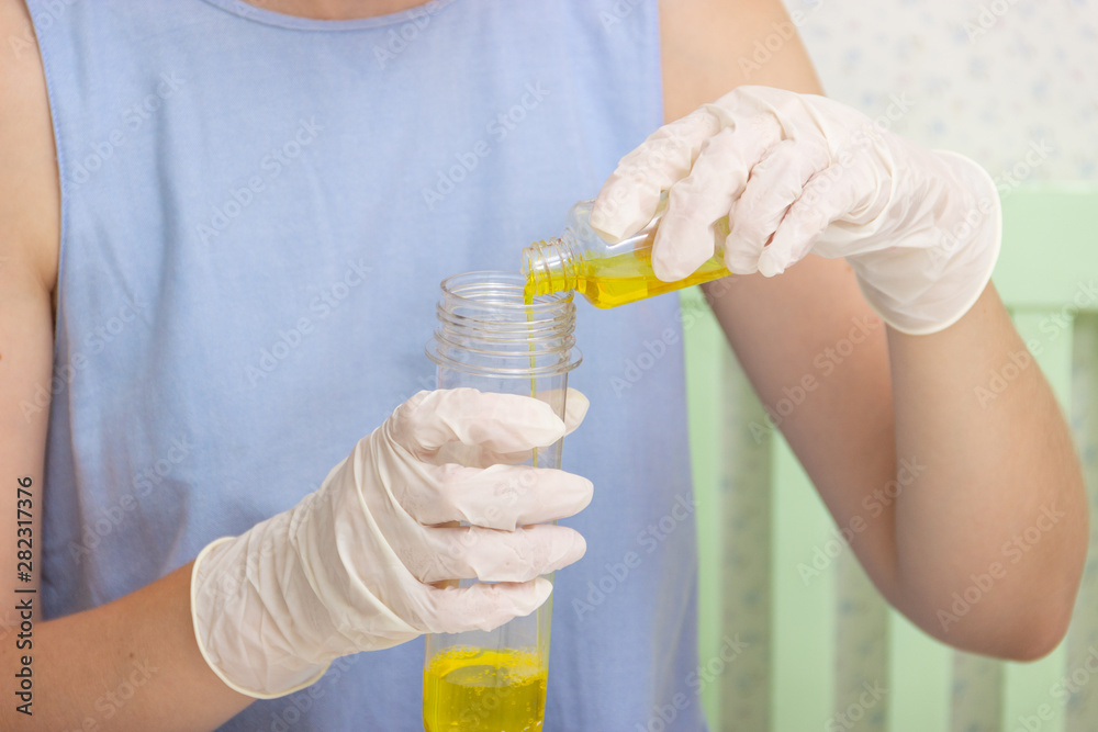 Young beautiful girl shows how to make slime.. hands in medical gloves ...