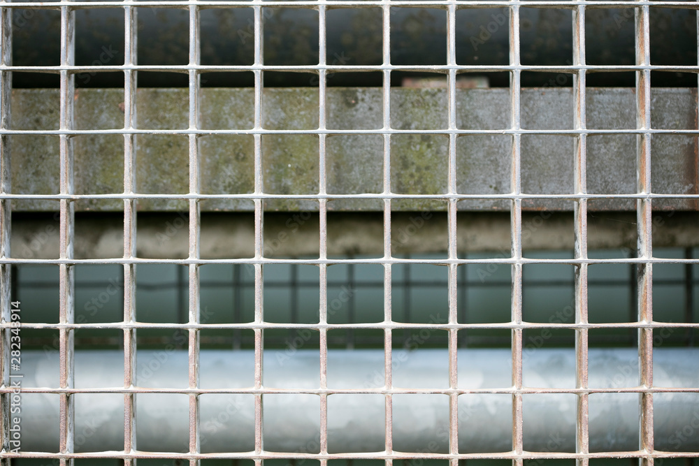 Jail metallic window with small quadrants diagonal strait lines macro ...
