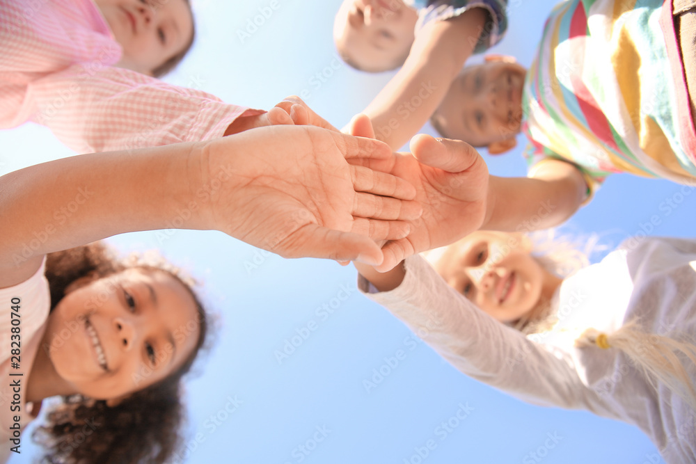 Cute little children putting hands together outdoors, bottom view Stock ...