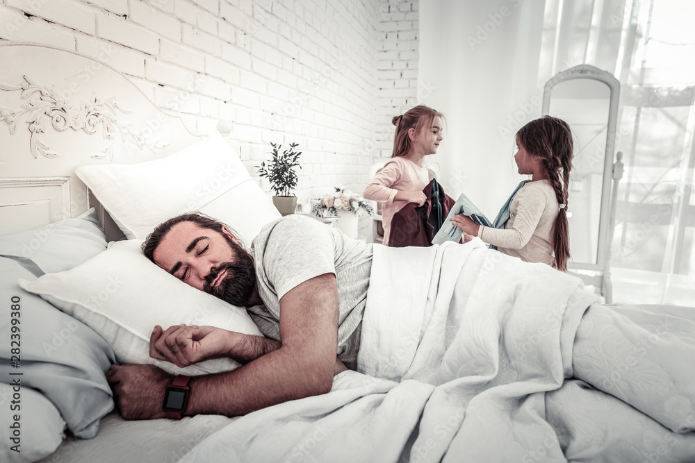 Sleeping dad with his two kids in background about to wake him up Stock ...
