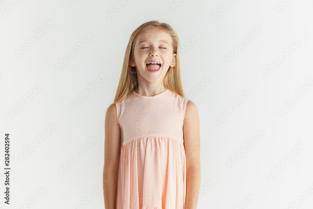 Stylish little smiling girl posing in dress isolated on white studio ...