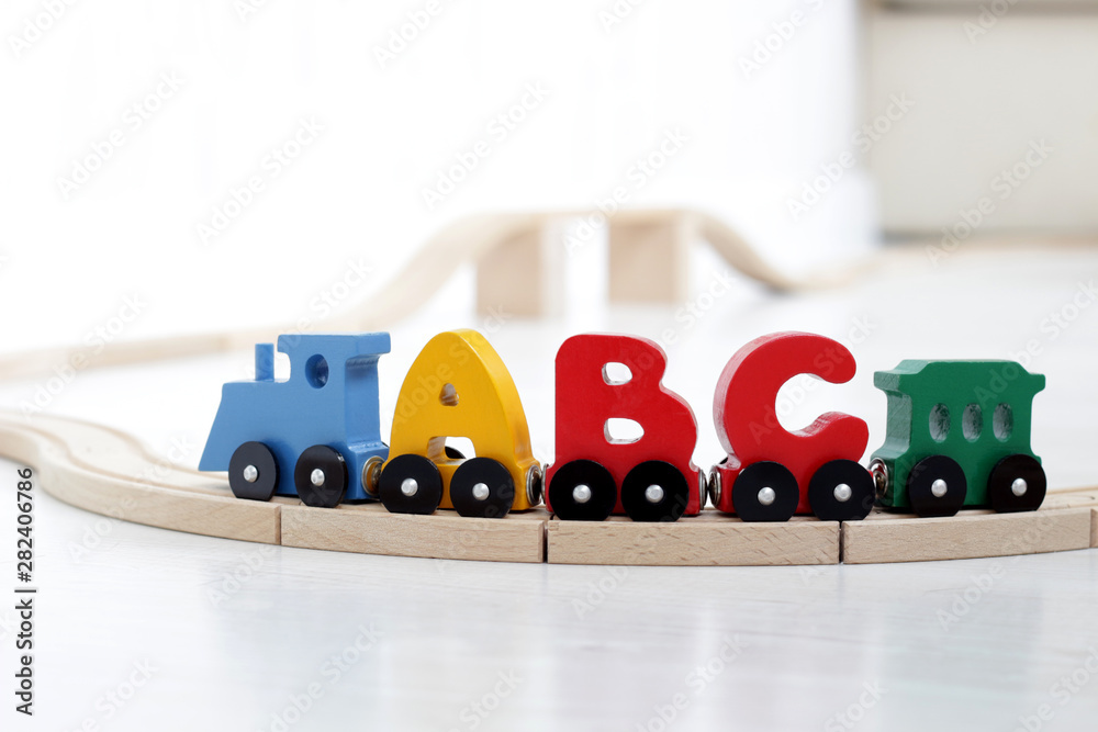 wooden letters of alphabet train on rails in playroom. steam train ...