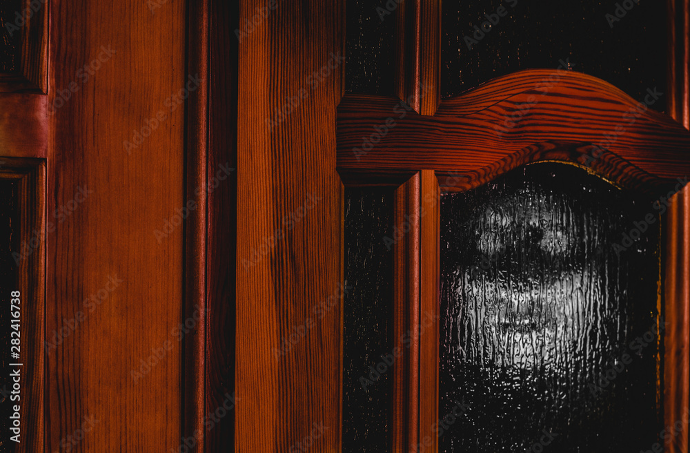 Creepy creature looks out the window. Halloween poster with copy space ...