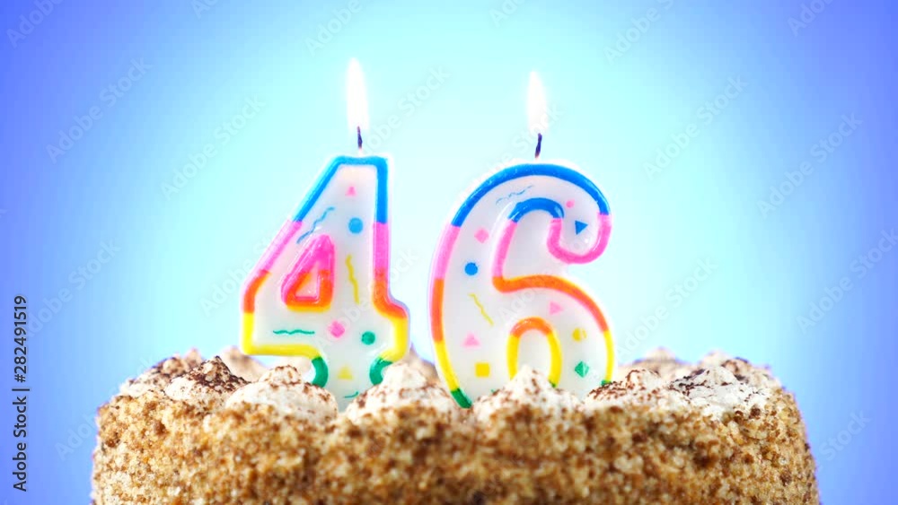 Birthday cake with a burning birthday candle. Number 46. Background ...