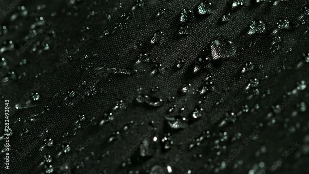 Super slow motion of falling water drops on waterproof cloth texture in ...