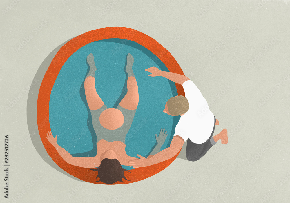 Directly above view of pregnant woman lying in birth pool with man ...
