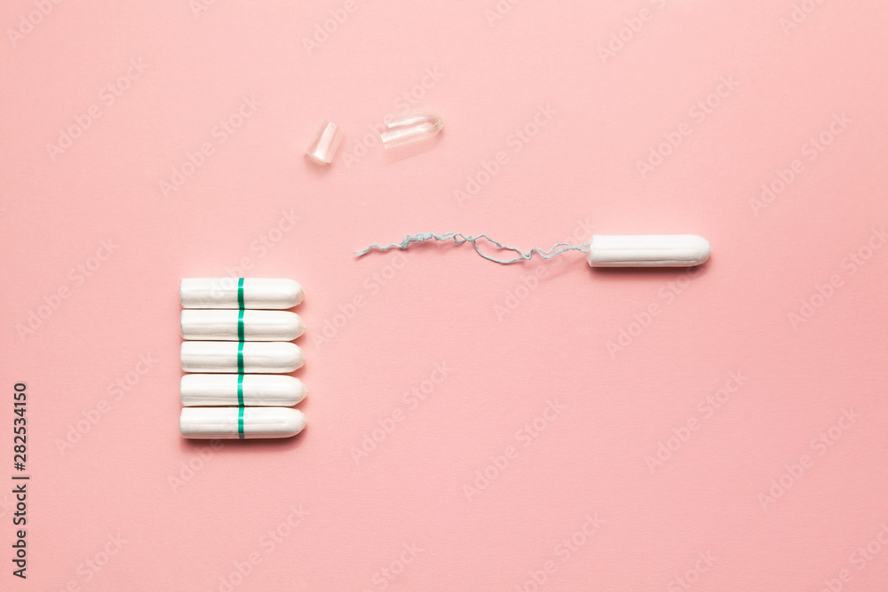 Unpacked tampons on a soft pink background. Modern female intimate ...