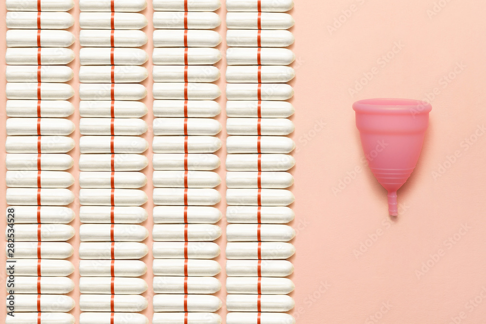 Reusable silicone menstrual cup and heap of tampons comparison on a ...