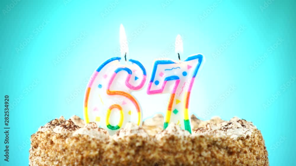 Birthday cake with a burning birthday candle. Number 67. Background ...