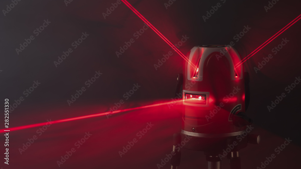 laser level tool red light beams in smoke Stock Photo | Adobe Stock