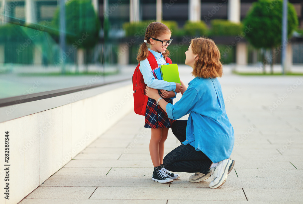 first day at school. mother leads little child school girl in first ...