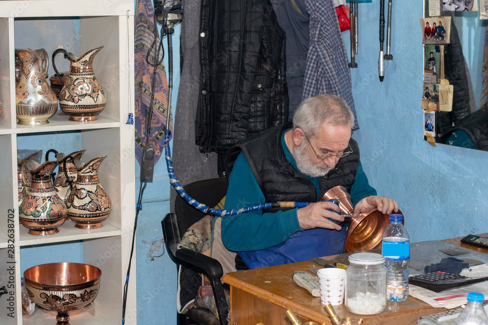 Coppersmith is working in his shop in Suleymaniye, Istanbul. Copper ...
