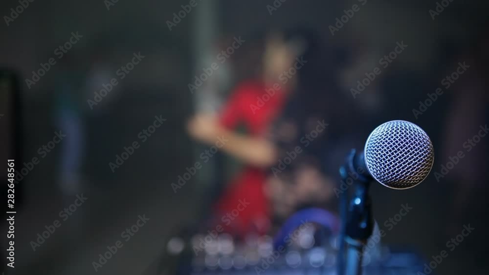 A microphone on stage, people are dancing on the dance floor. Dance ...