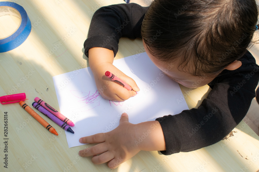 little girl drawing with crayons on paper.topview Stock Photo | Adobe Stock