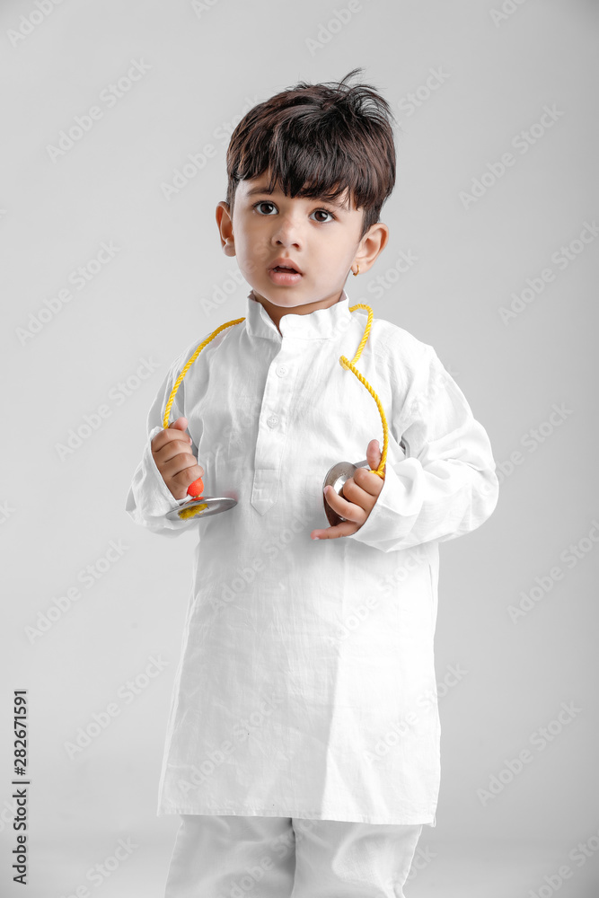 Indian Little Boy in Traditional Dress and learning with Musical ...