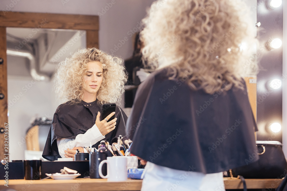 Beautiful young girl model with white hair takes a selfie in a beauty ...