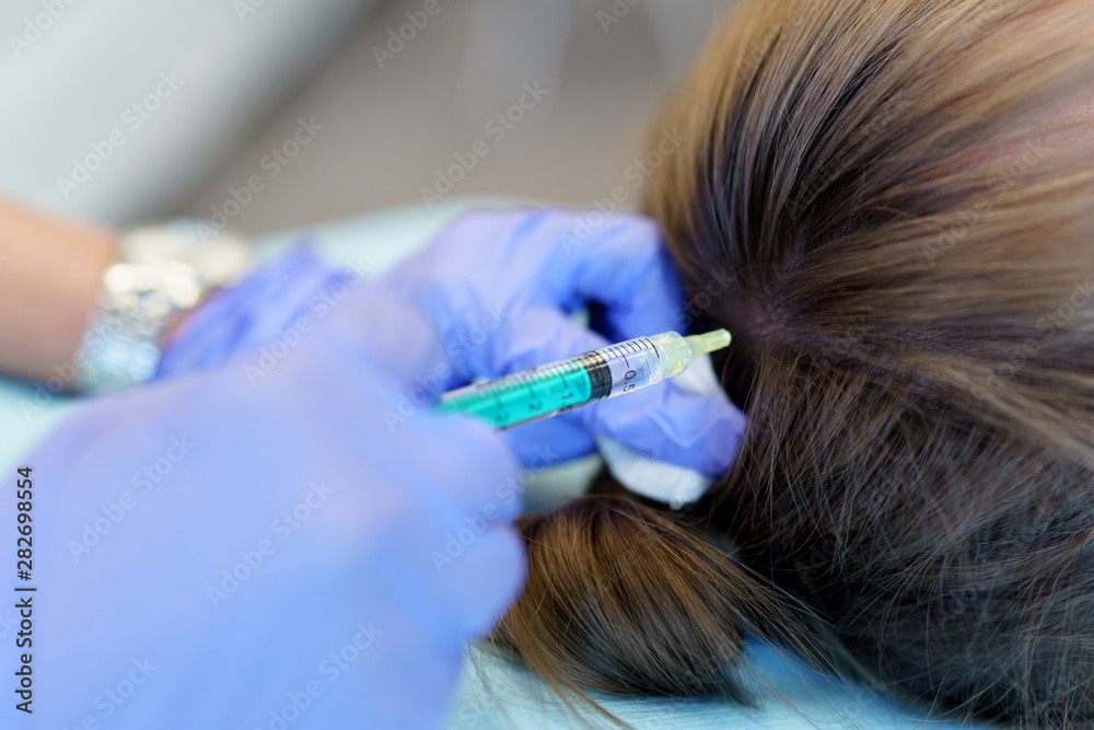 Needle mesotherapy. Cosmetic been injected in woman's head. Thrust to ...