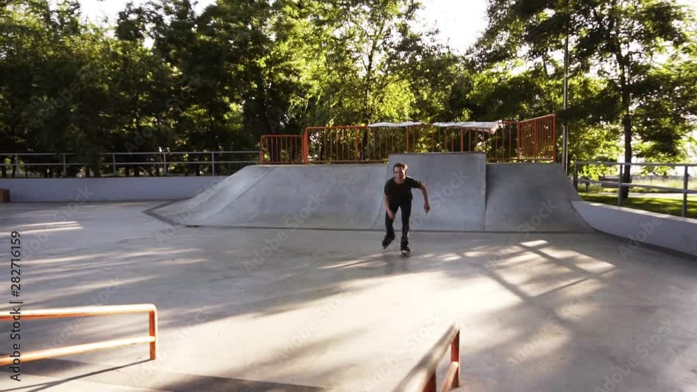 Inline roller skater doing tricks in concrete skatepark outdoors with ...
