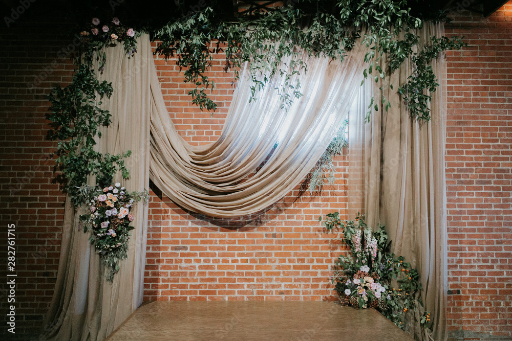 Wedding ceremony alter with hanging fabric, greenery, and flowers ...