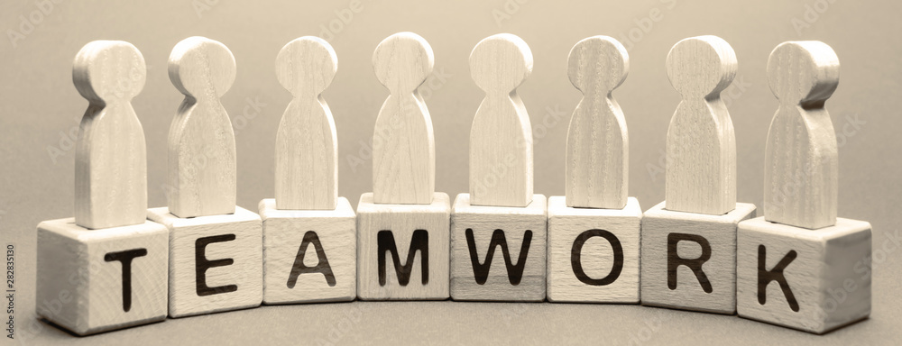 Wooden blocks with the word Teamwork and business team of employees ...