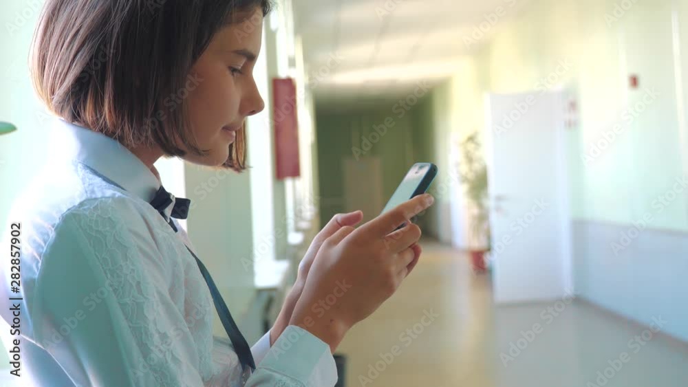 schoolgirl education with smartphones at school concept. Young girl ...