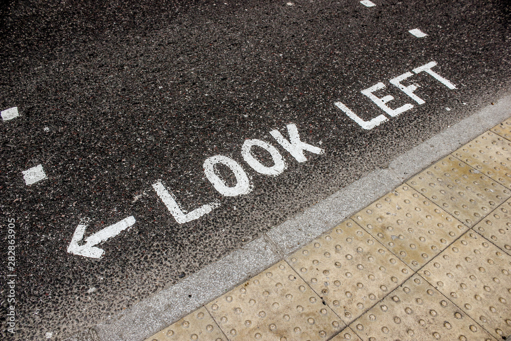 Vintage looking look left sign on London zebra crossing road. Road ...