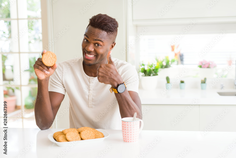 African american man eating healthy whole grain biscuit happy with big ...