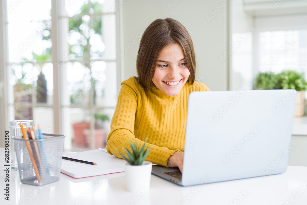 Beautiful young girl studying for school using computer laptop with a ...