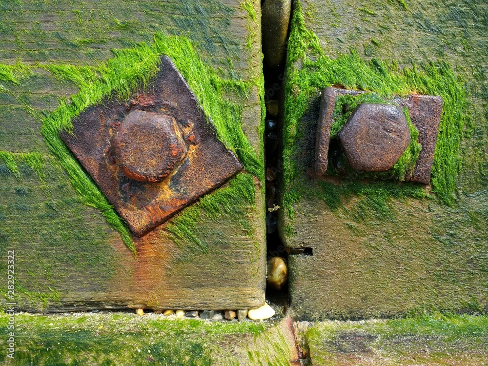 Close up of sea wall on coastal barrier in wood bolted together with ...